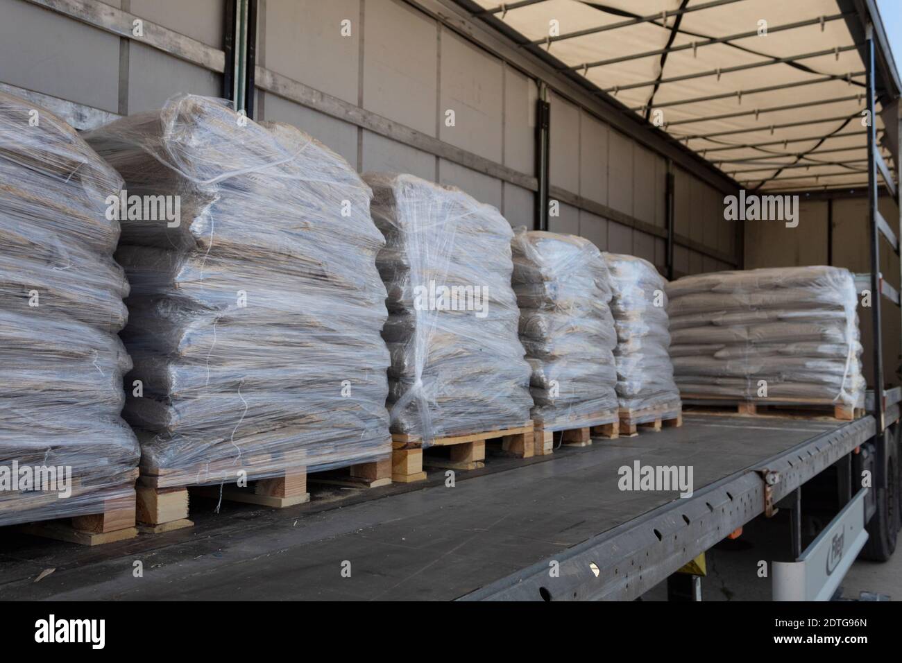 Loading goods onto a truck trailer. Unloading a trailer of pallets with ...