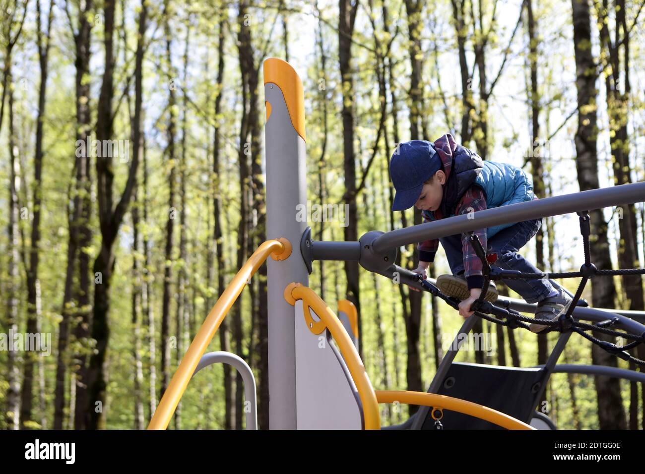 Kid climbing in playground at summer park Stock Photo - Alamy