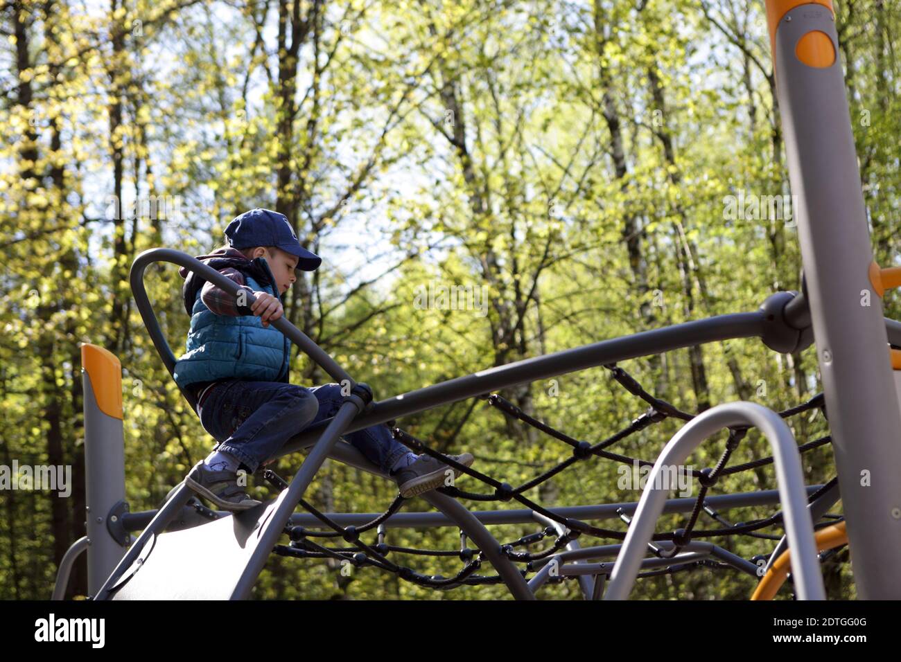 Boy climbing in playground at summer park Stock Photo - Alamy