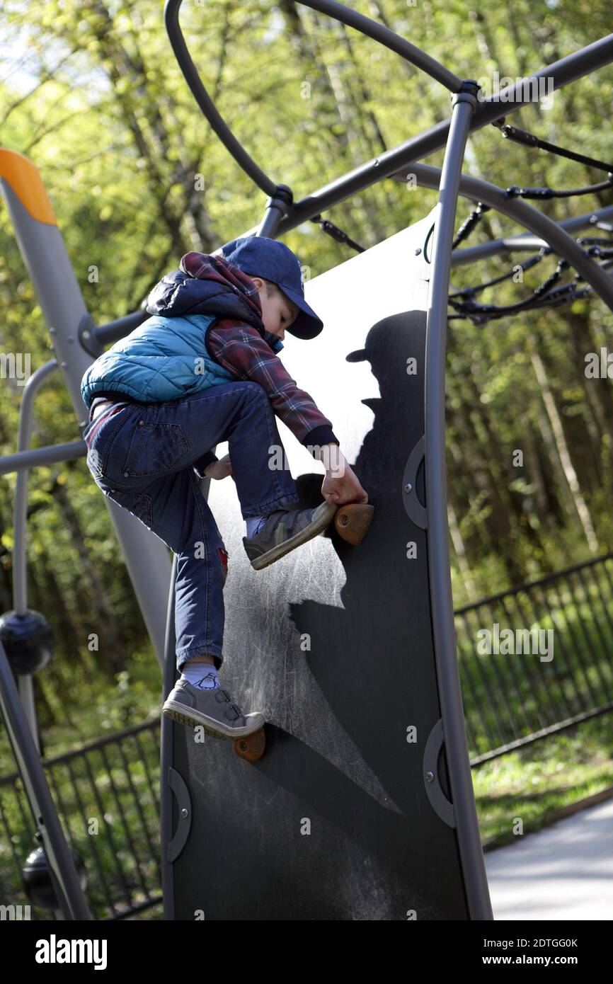 Child climbing in playground at summer park Stock Photo - Alamy