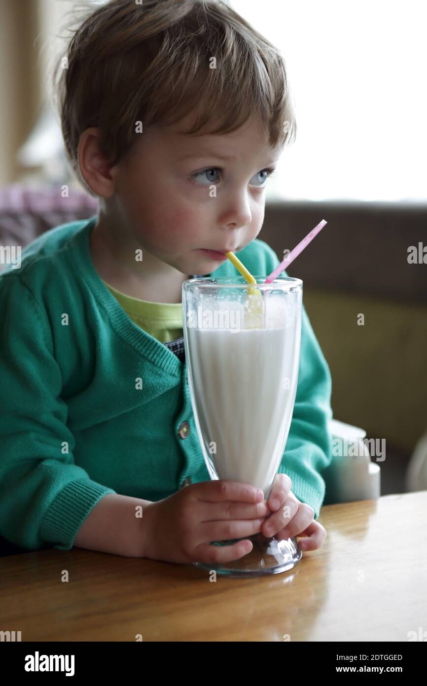 Boy is drinking milkshake in a cafe Stock Photo - Alamy