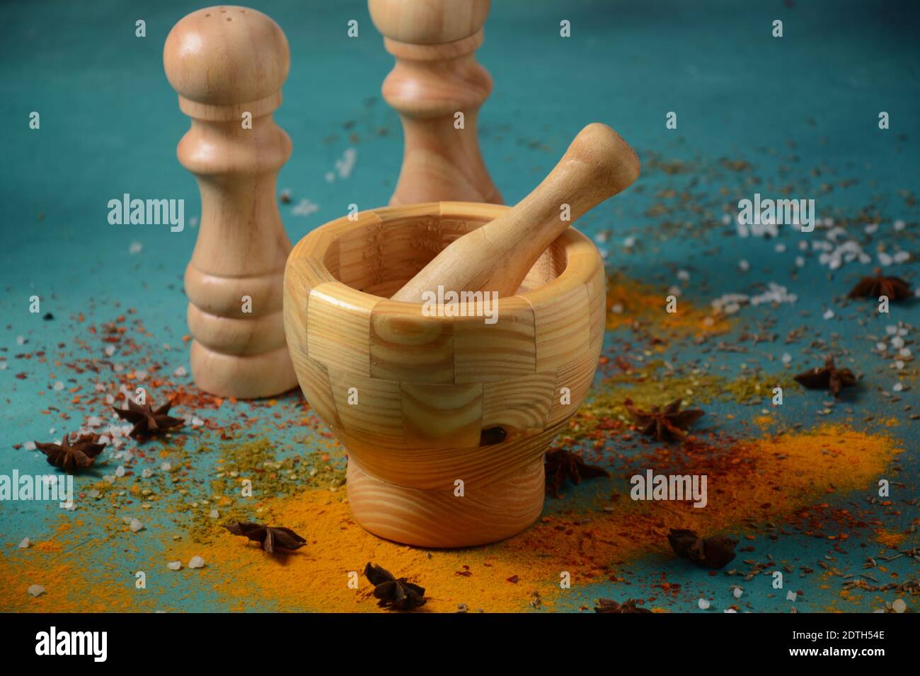 Wooden spice mortar and spices on blue background Stock Photo - Alamy