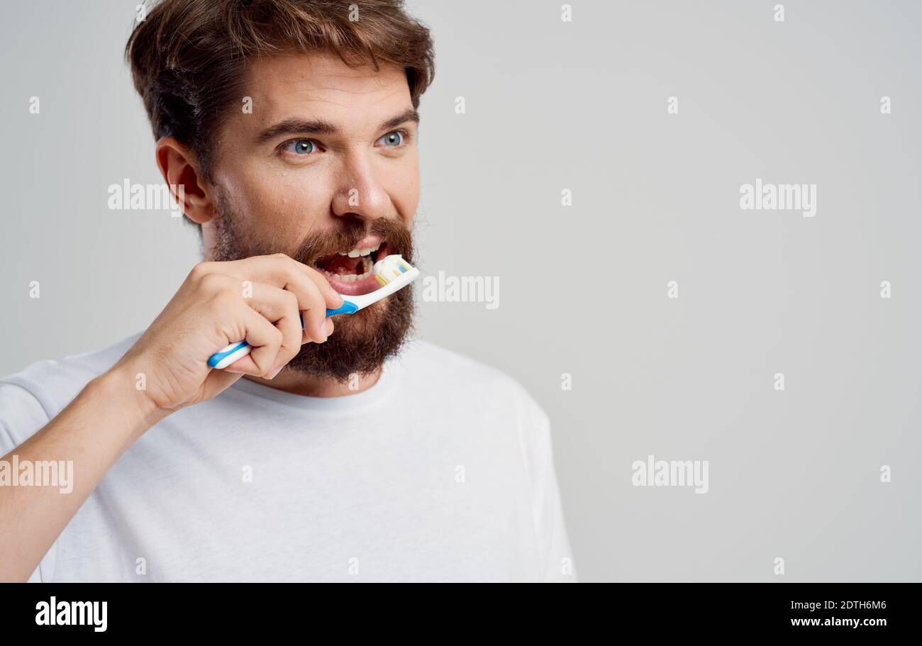 handsome man brushing teeth oral care light background morning ...