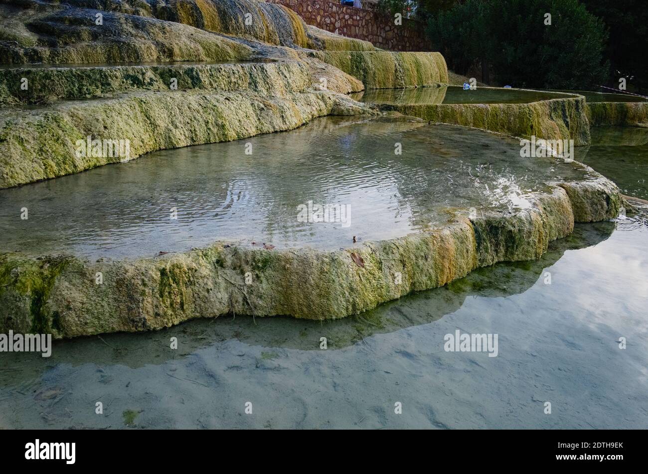 Red travertine terraces in Karahayit. Clear thermal water baths ...