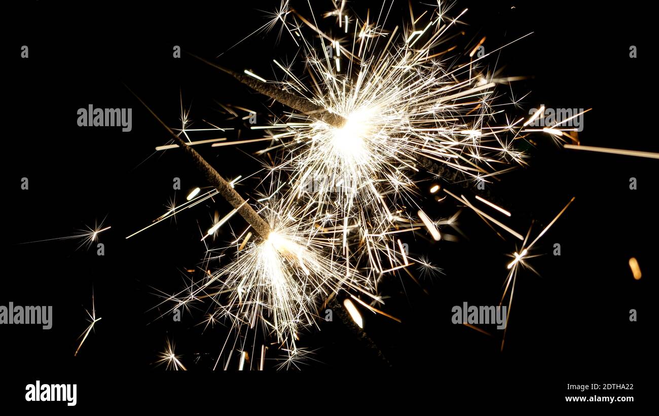 Christmas sparklers glow with sparks in the dark Stock Photo - Alamy