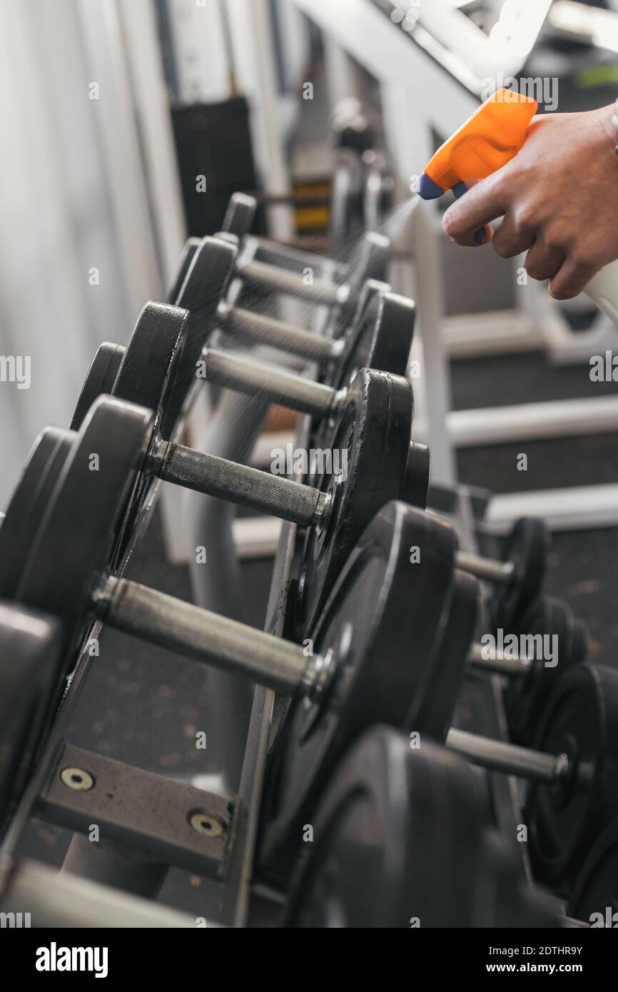 Man spraying weights in a gym. Concept of health and sport Stock Photo ...