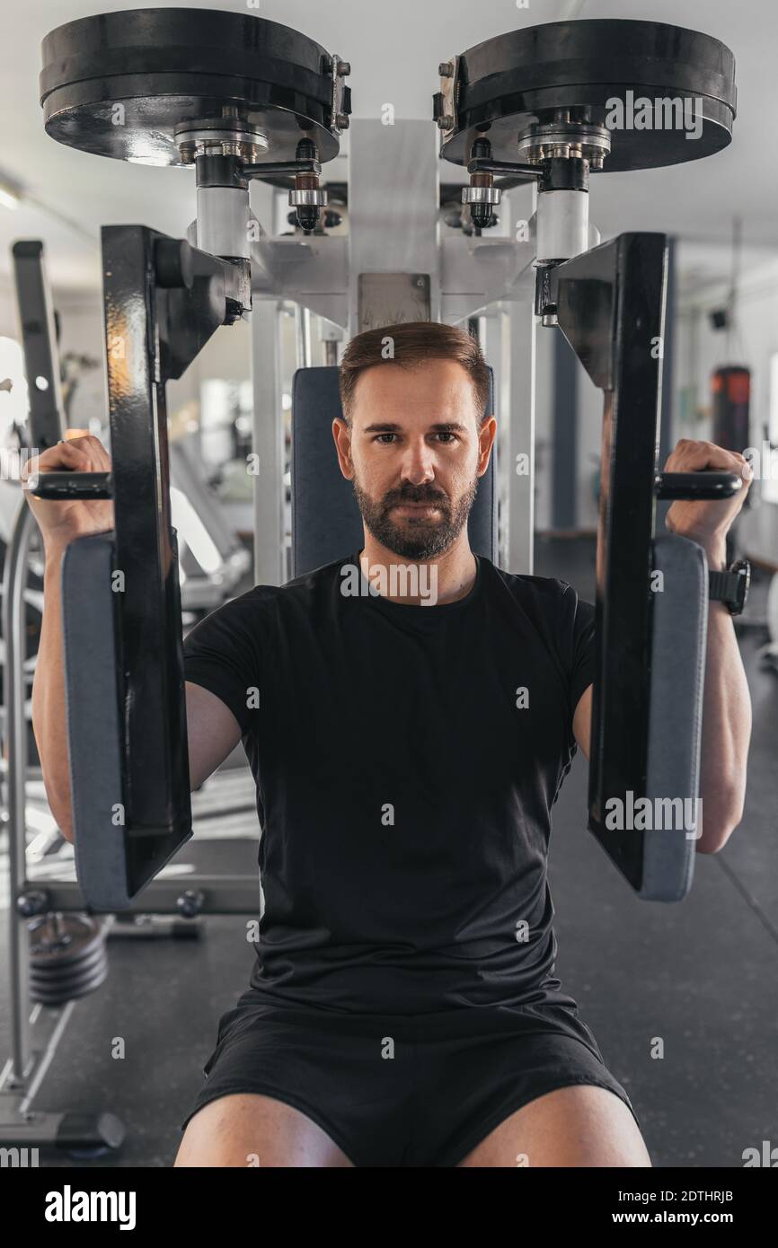Man working hard at the gym. Pectoral muscles exercises with training ...