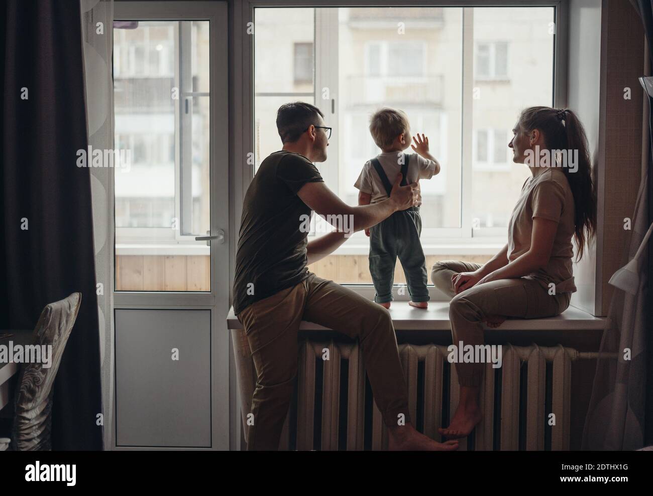 Happy family with little son playing on window at home Stock Photo - Alamy