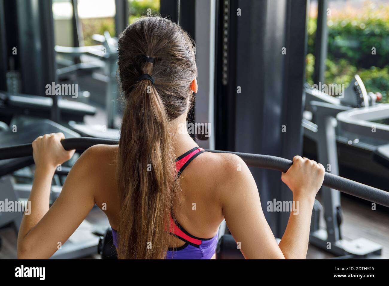 Woman doing exercise for her back in the gym. Lat pulldown Stock Photo ...