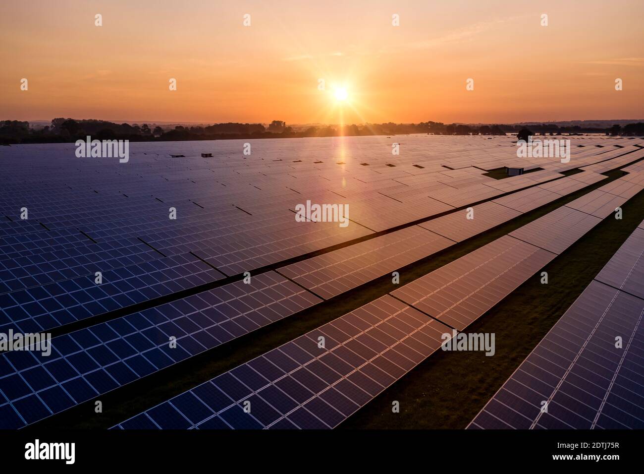 Aerial looking over a modern solar farm at sunrise in the English ...