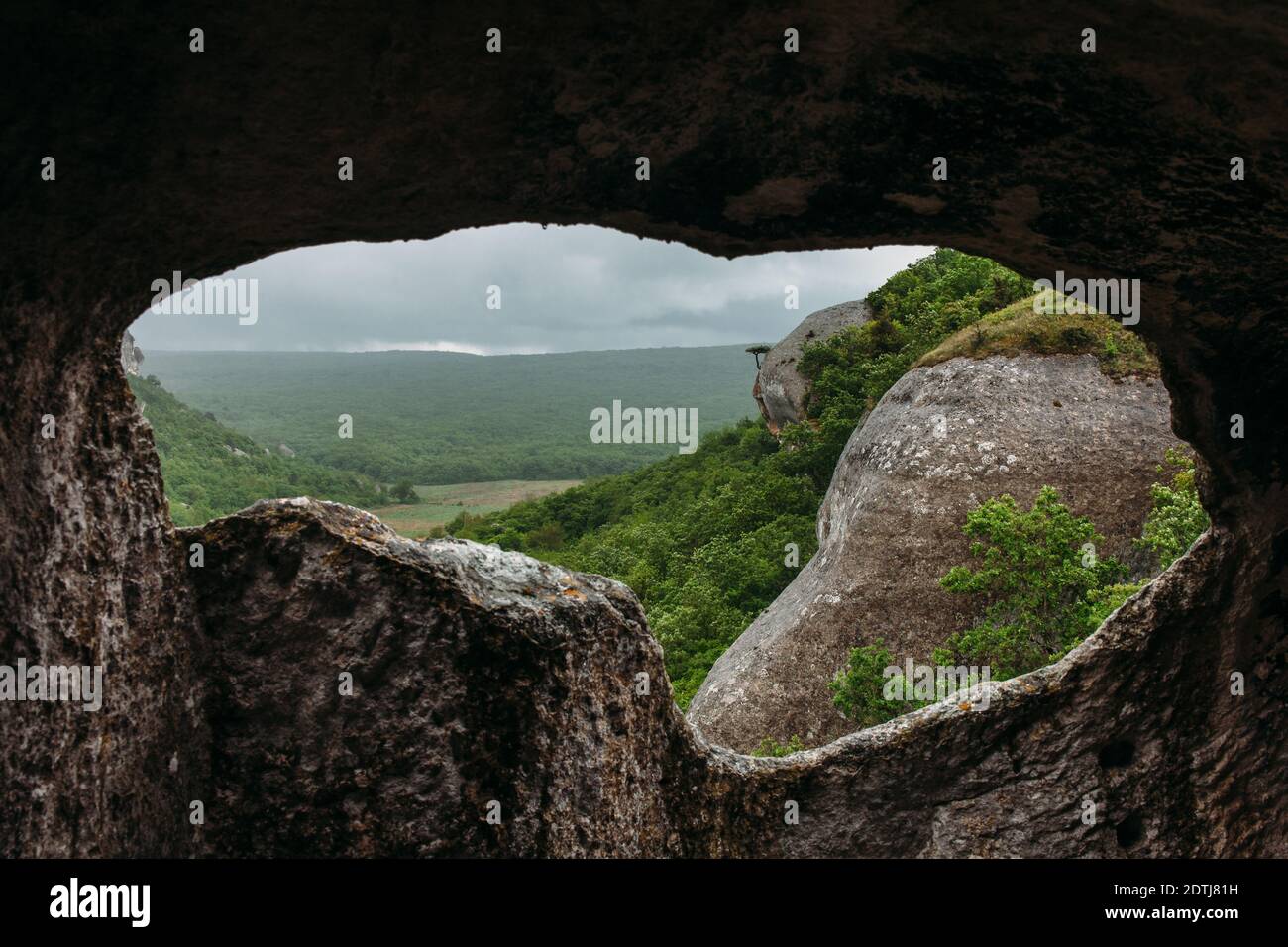 View from the ancient cave to the green mountain forest valley ...