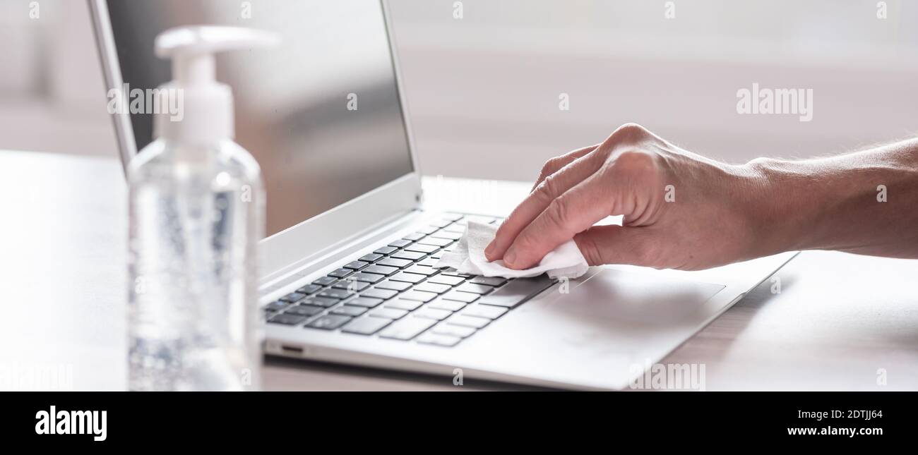 Woman disinfecting laptop keyboard with antibacterial wipe; prevention ...