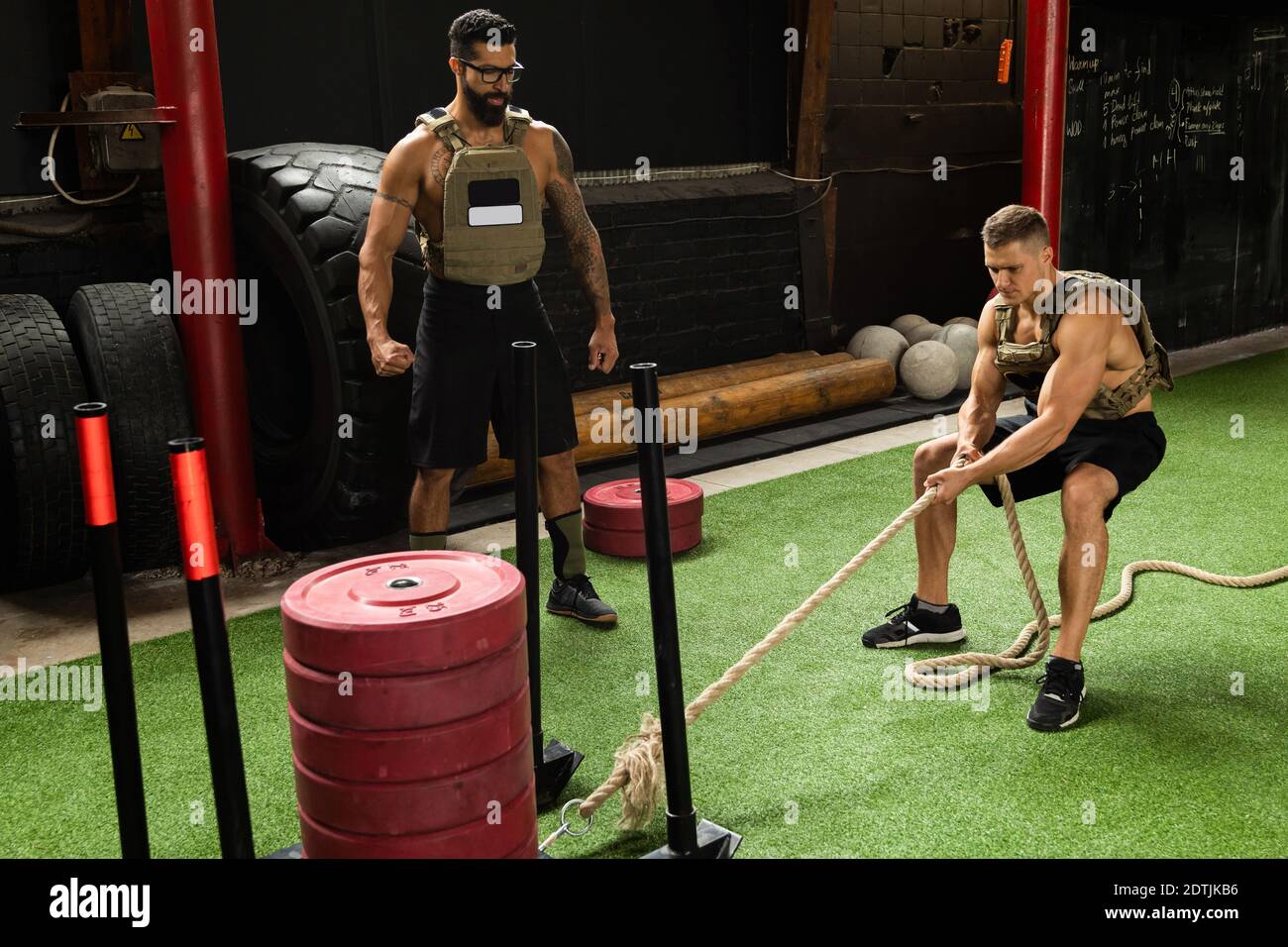 Strong sportsman during his cross training workout. Sled drag exercise ...