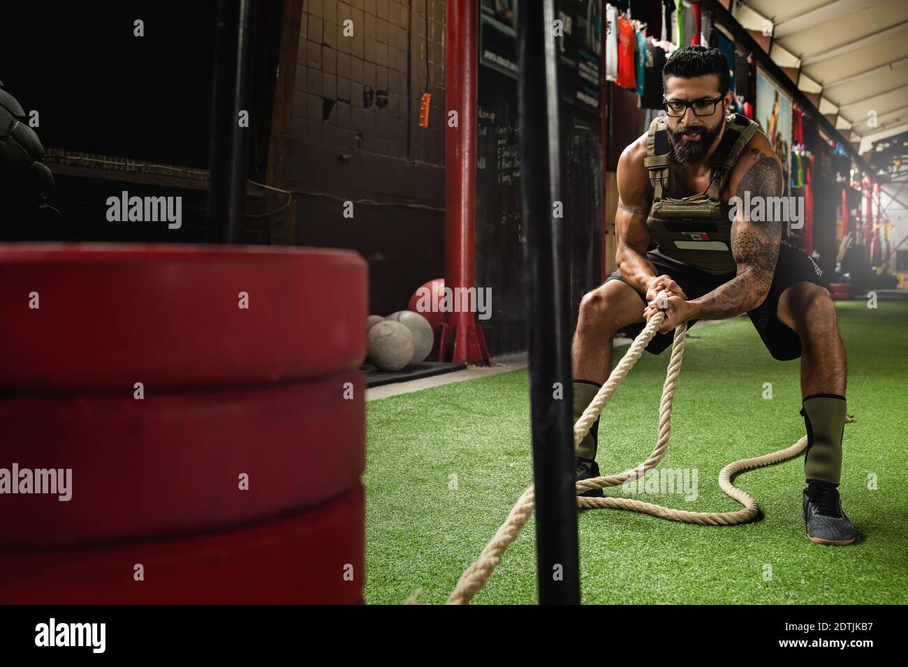 Strong sportsman during his cross training workout. Sled drag exercise ...