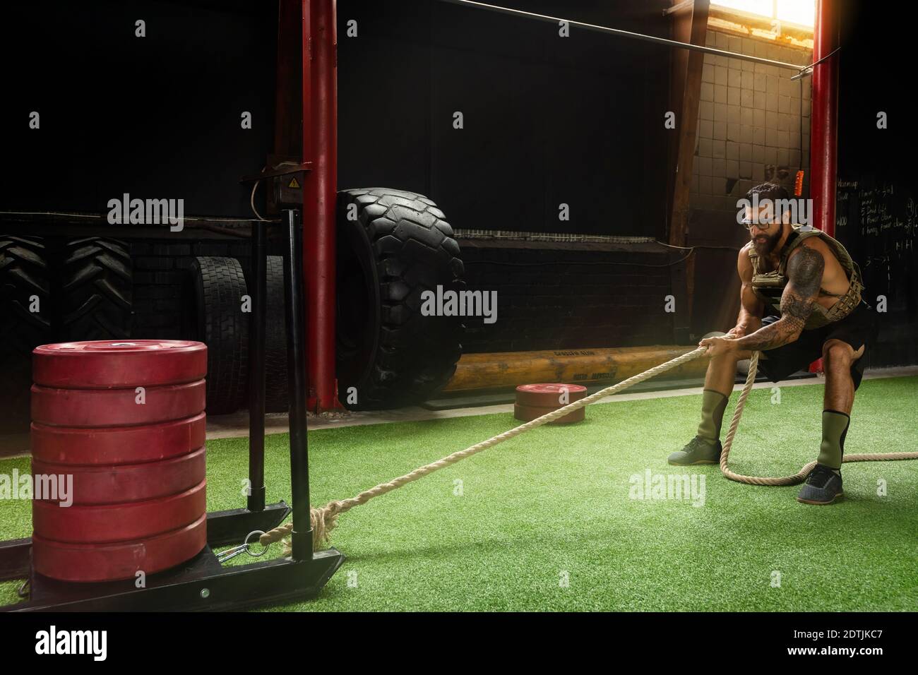 Strong sportsman during his cross training workout. Sled drag exercise ...