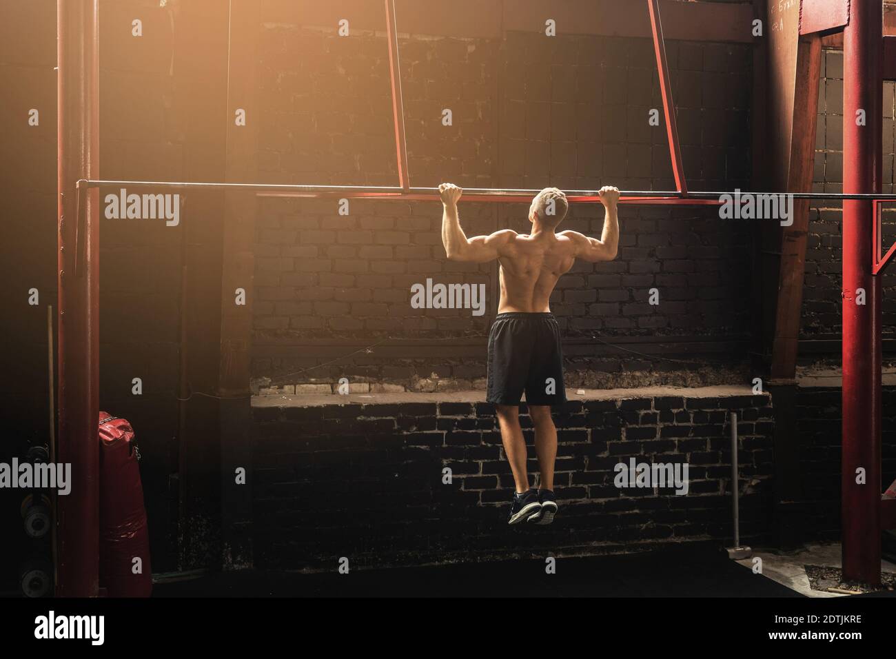 Man doing pull up exercise. Sportsman during his workout in the gym ...