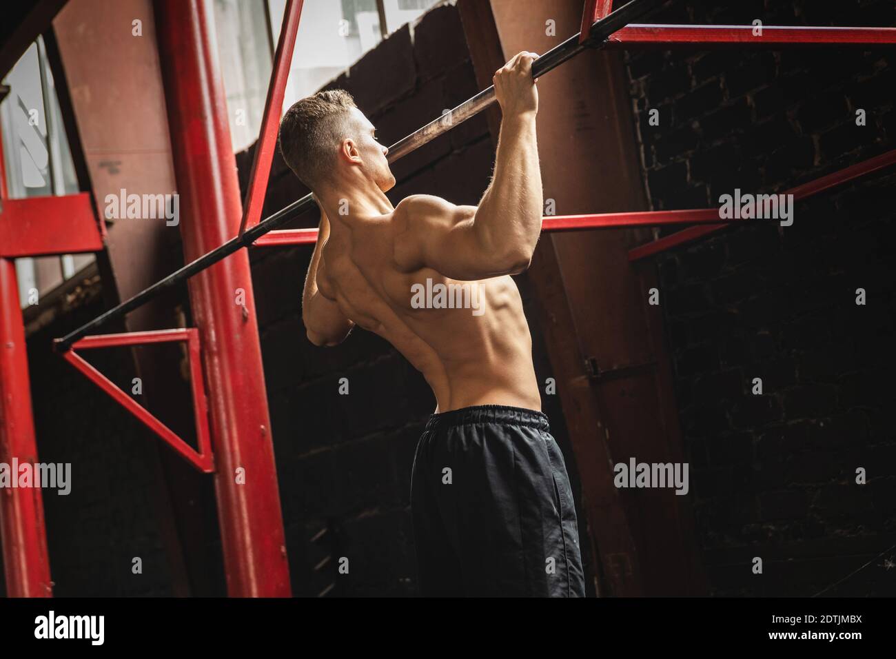 Man doing pull up exercise. Sportsman during his workout in the gym ...