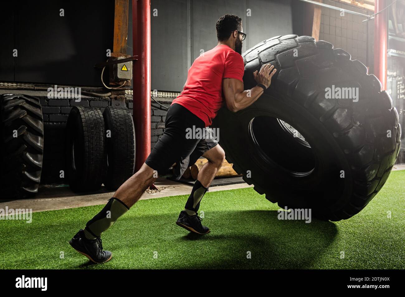 Tire flip exercise. Strong sportsman during his cross training workout ...