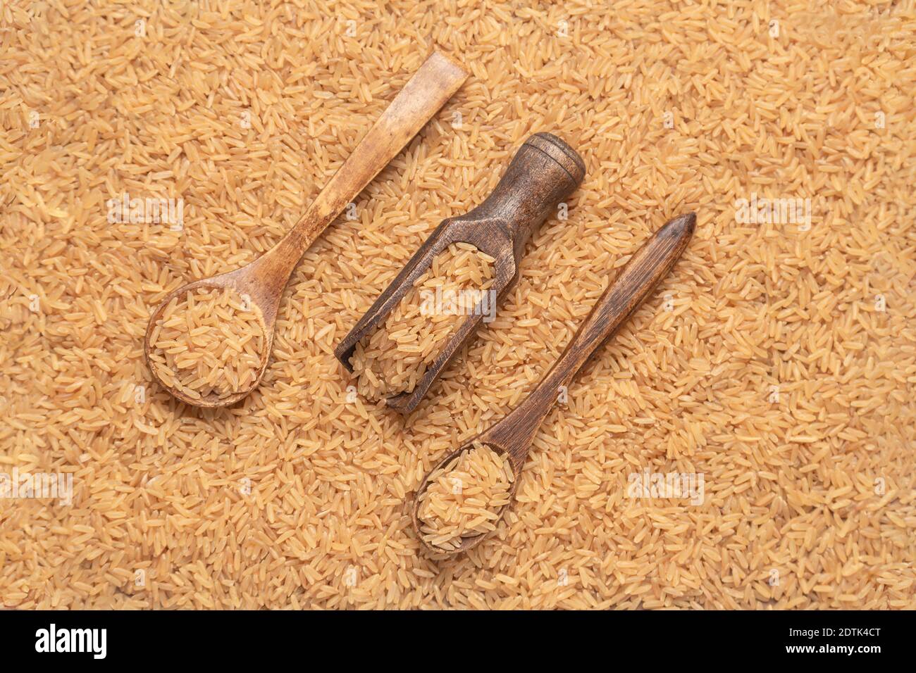 Three wooden spoons with brown rice on brown rice background Stock ...