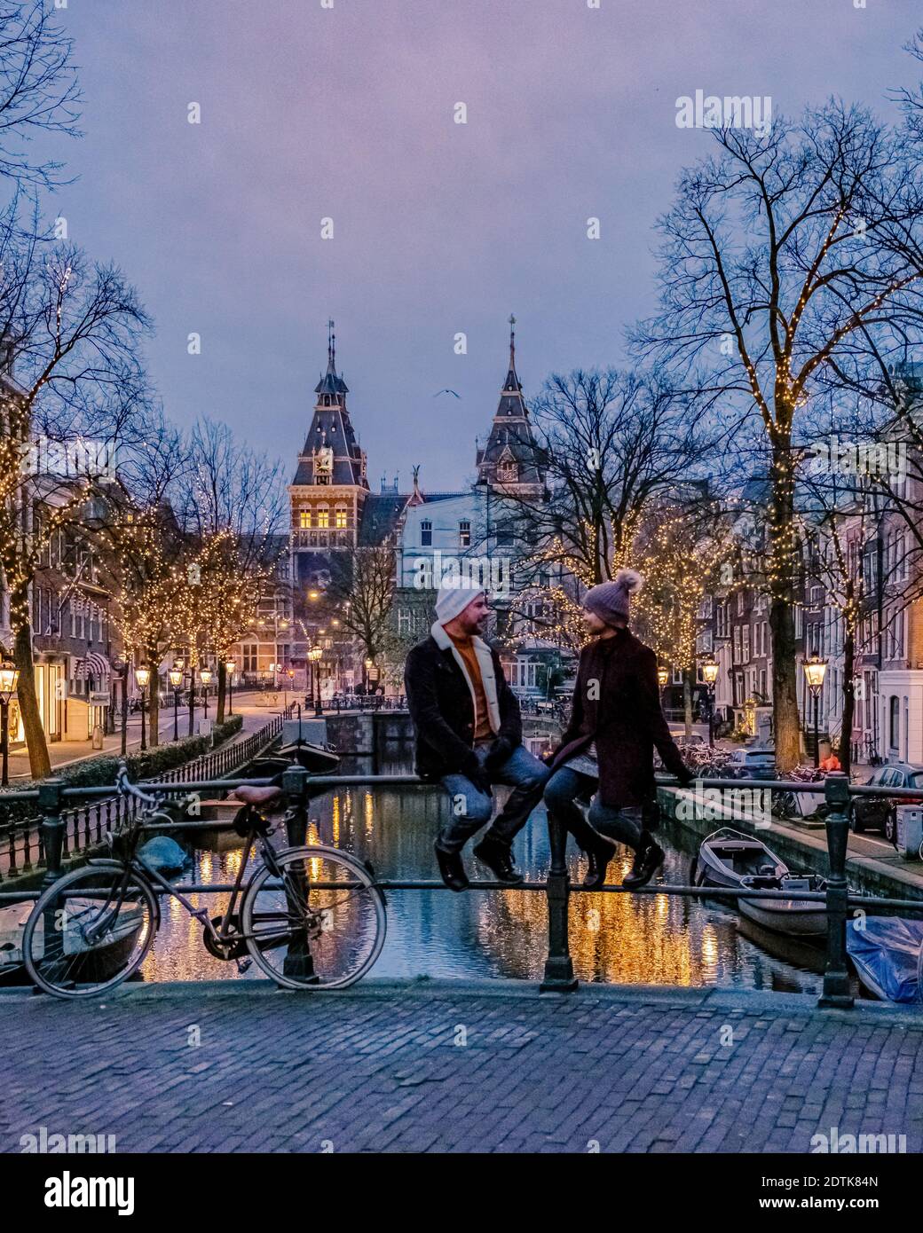 couple on city trip Amsterdam Netherlands canals with Christmas lights ...