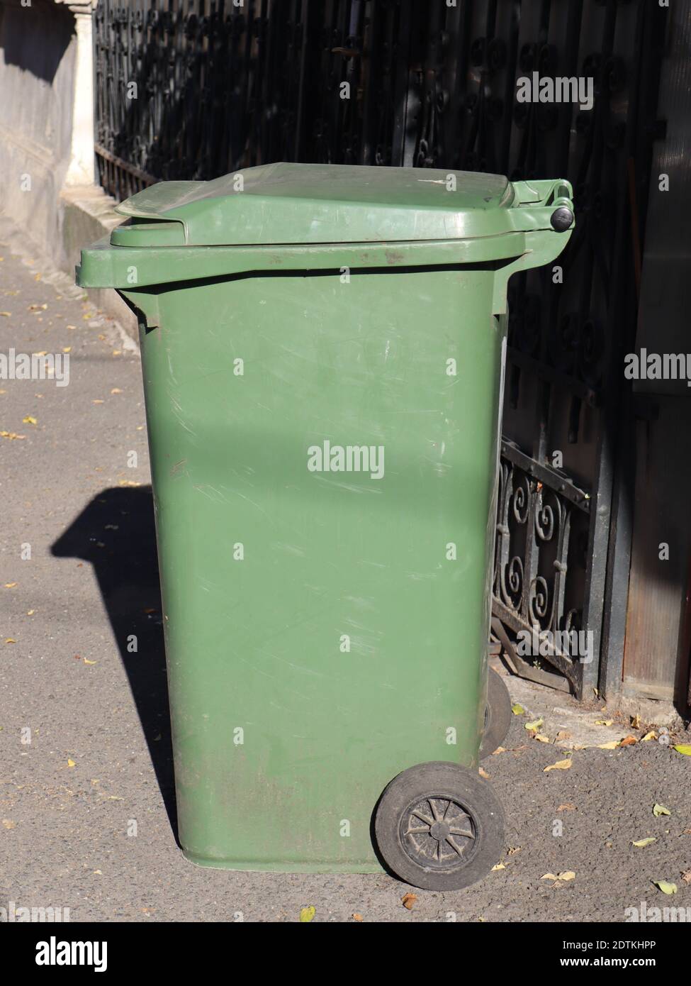 A vertical shot of a green recycle bin on the street Stock Photo - Alamy