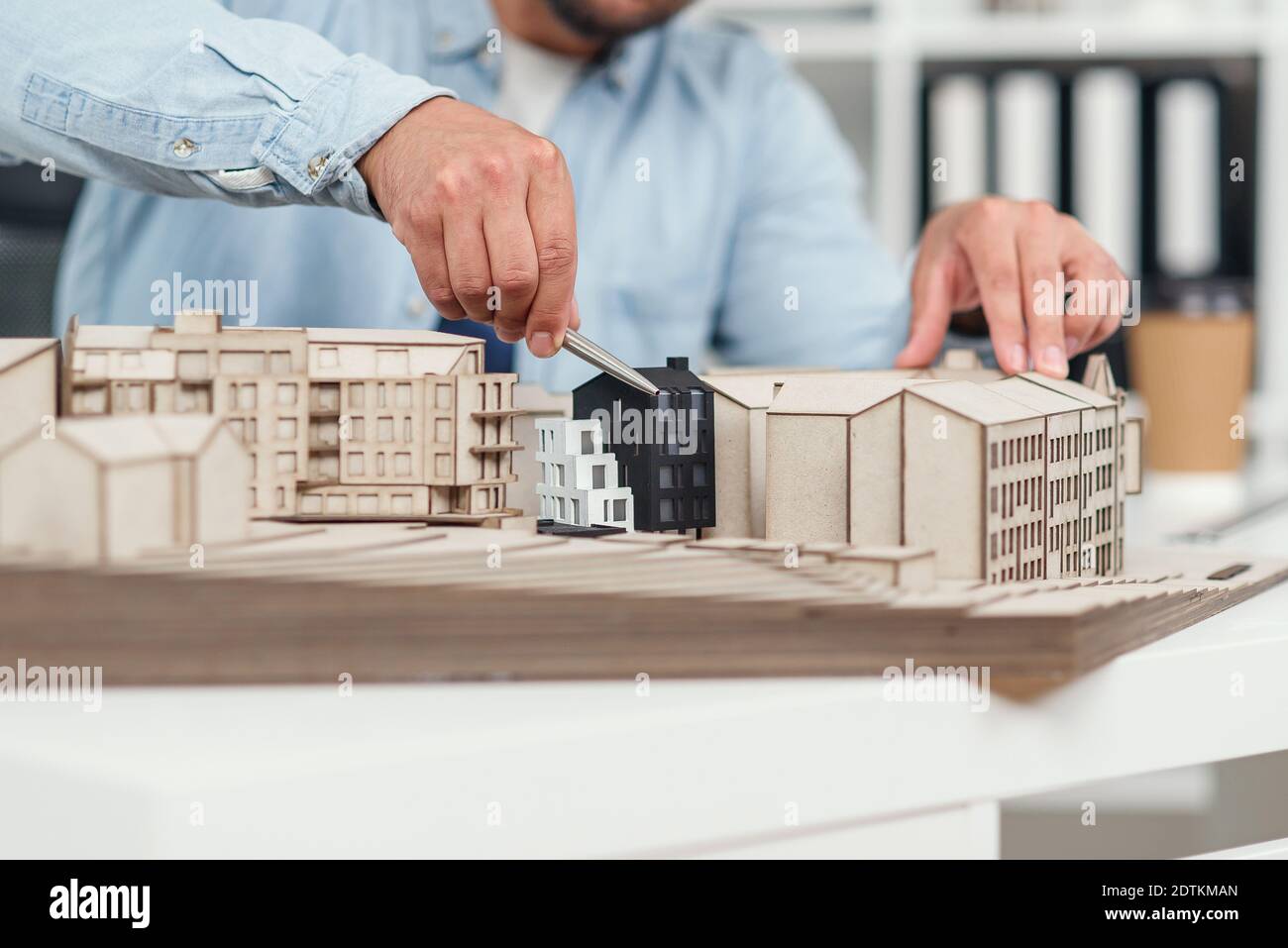 Close up architect's hands at constructing model of buildings and ...
