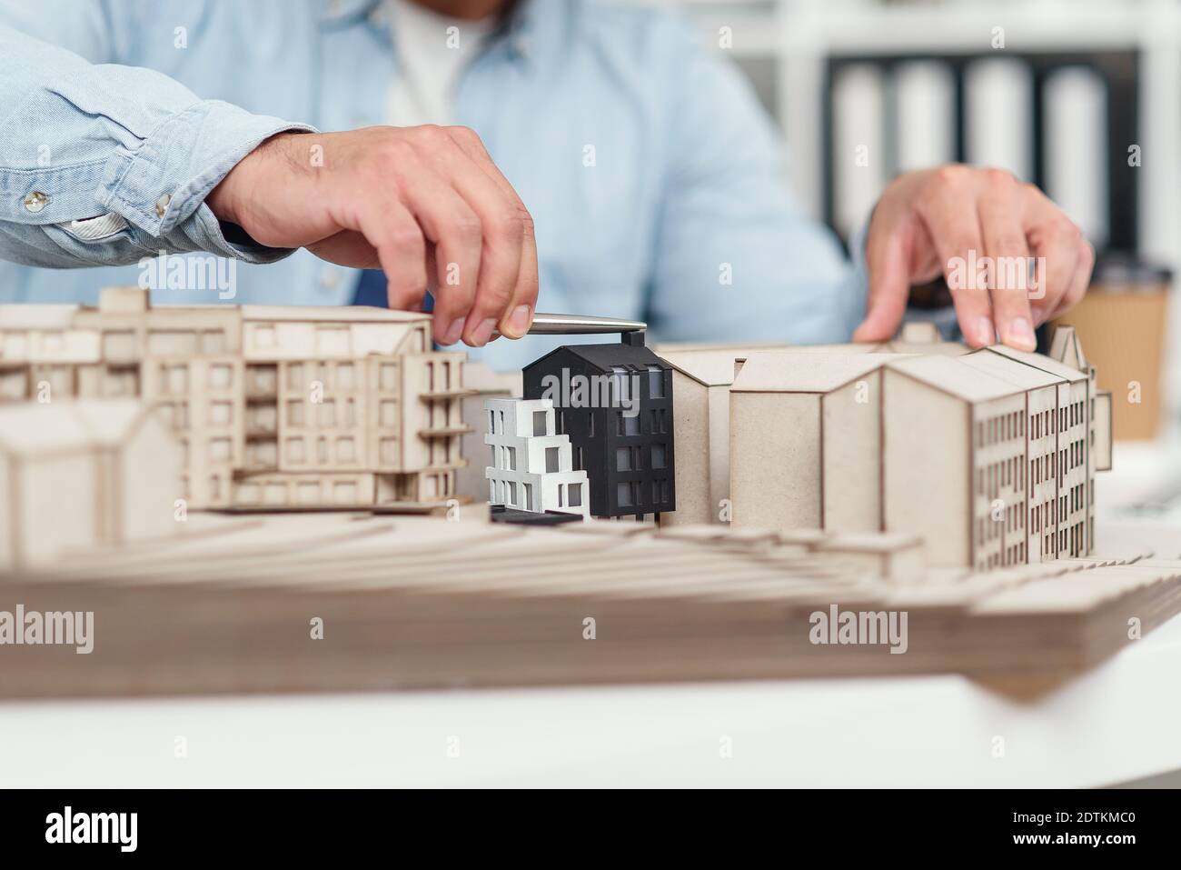 Close up architect's hands at constructing model of buildings and ...