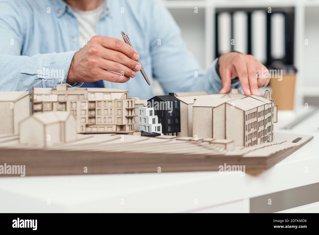 Close up architect's hands at constructing model of buildings and ...