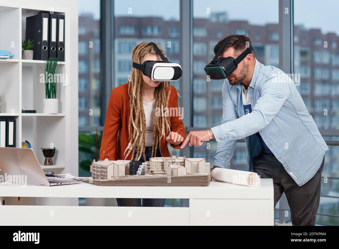 Professional architect working at office desk and wearing a VR headset ...