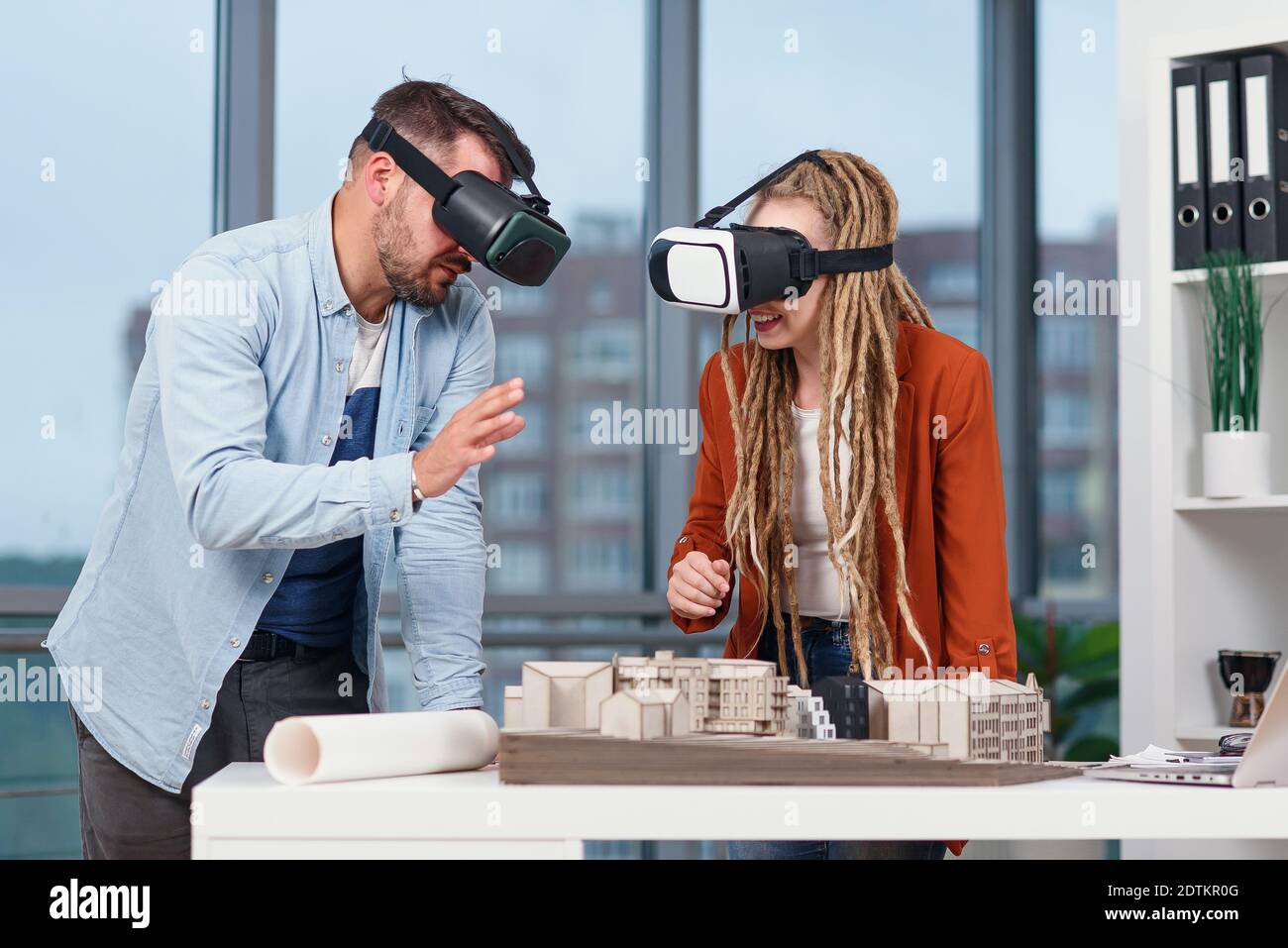 Professional architect working at office desk and wearing a VR headset ...