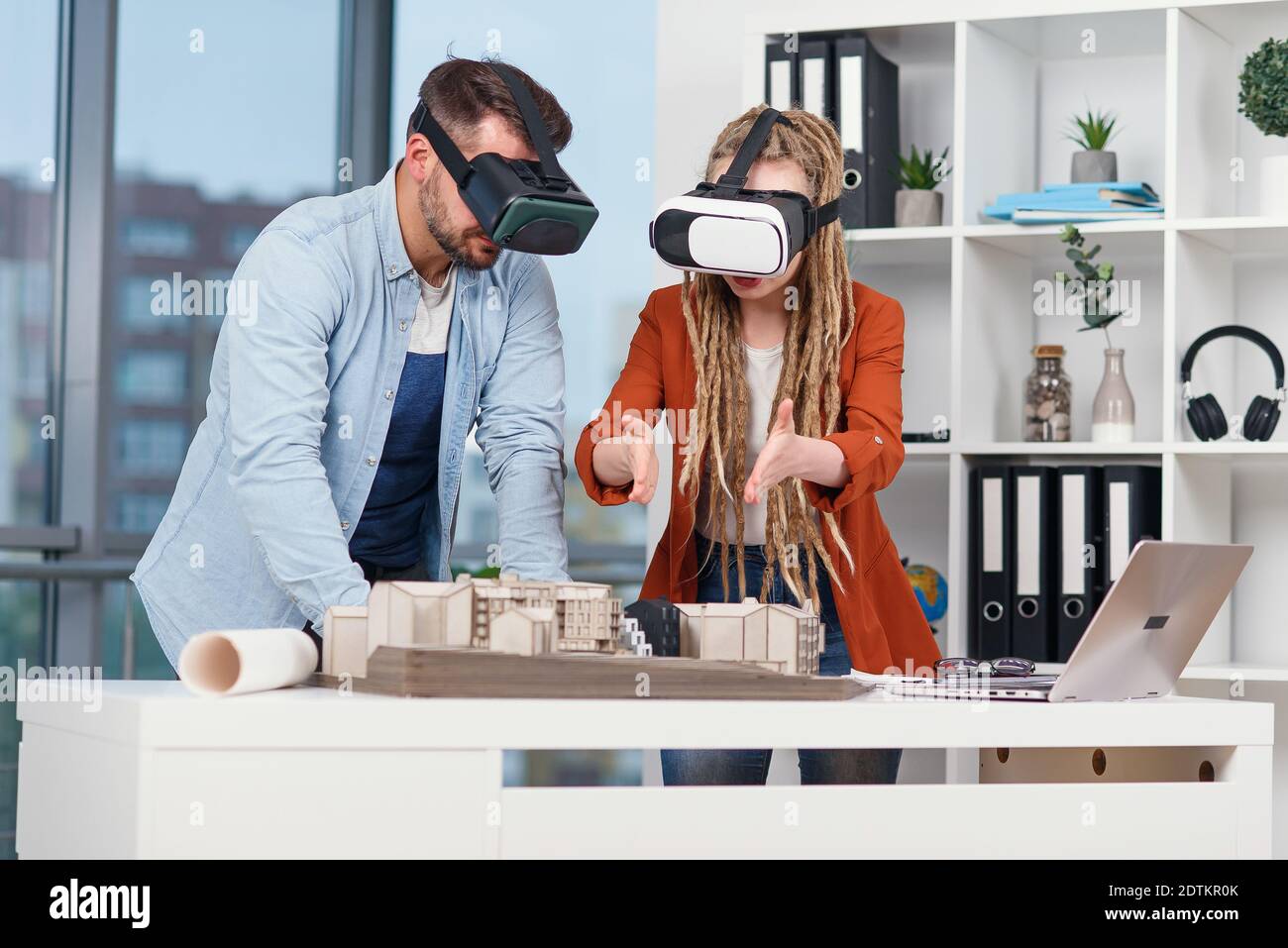 Professional architect working at office desk and wearing a VR headset ...
