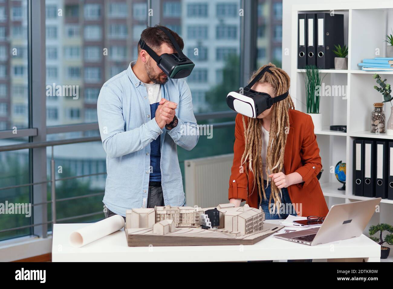 Professional architect working at office desk and wearing a VR headset ...