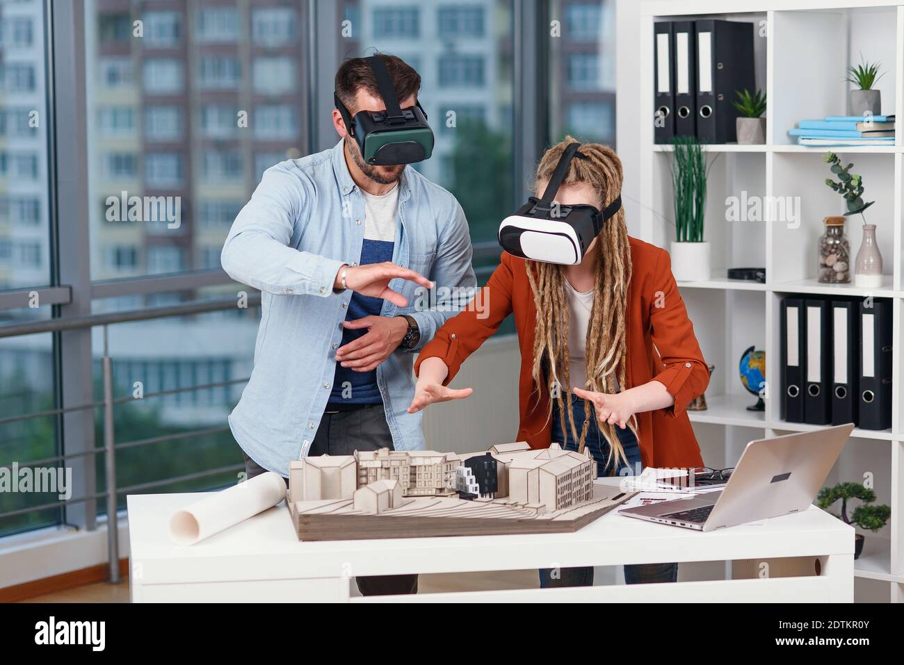 Professional architect working at office desk and wearing a VR headset ...