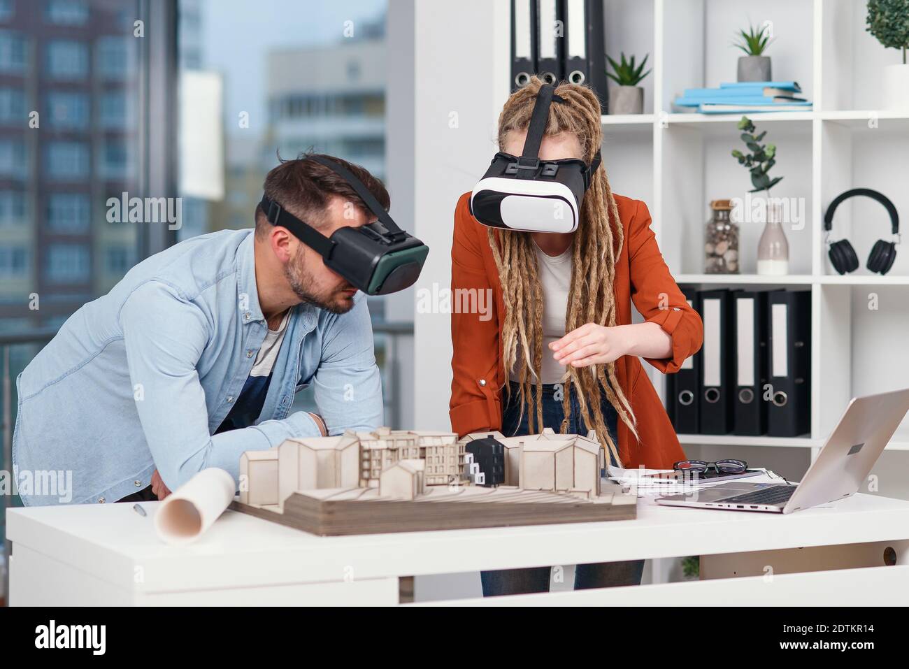 Professional architect working at office desk and wearing a VR headset ...