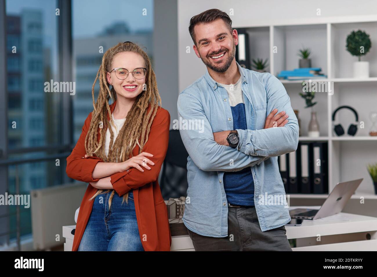 Professional architect stands back to back with pretty female colleague ...