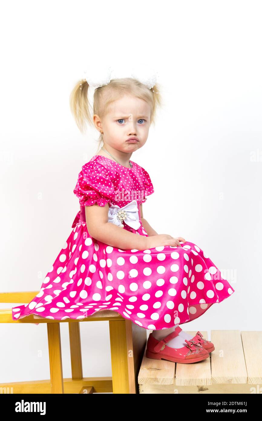 Portrait Of Cute Girl Sitting On Wooden Chair Against White Background ...