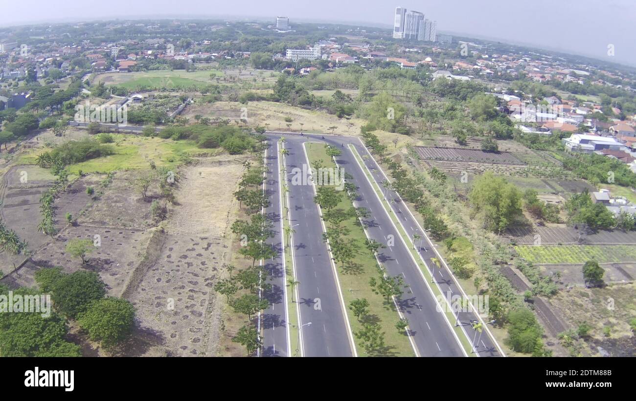 An aerial shot of a paved asphalt road and an urban city buildings ...