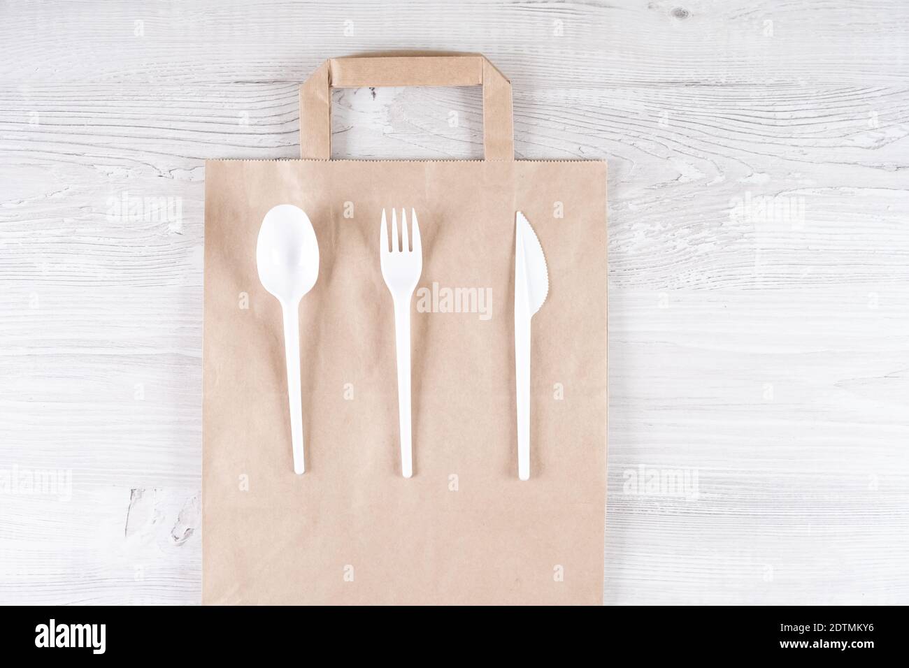 plastic fork, spoon, knife on paper bag. Eco-friendly food packaging ...