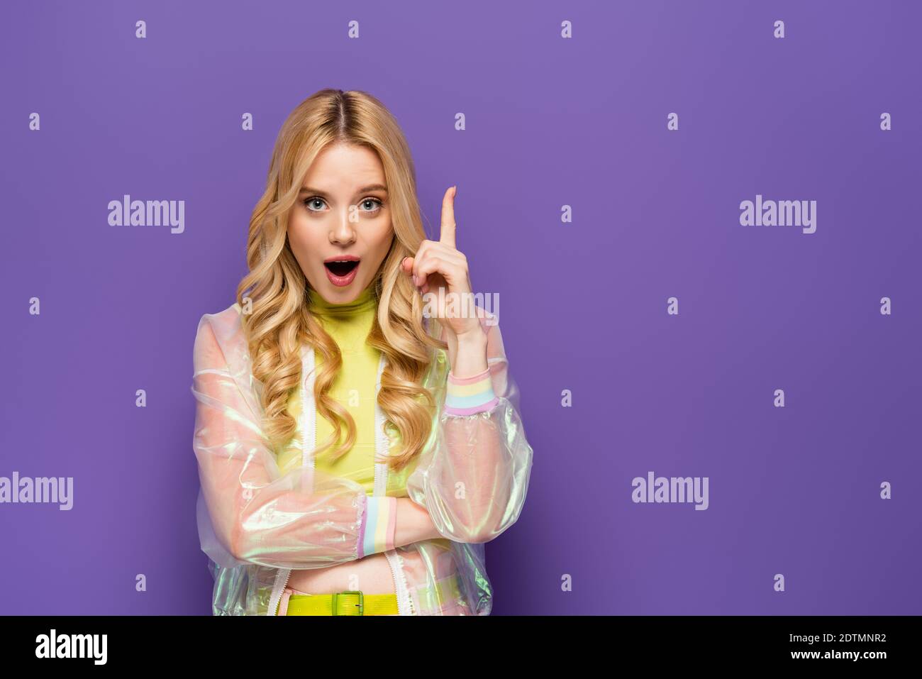 amazed blonde young woman in colorful outfit showing idea gesture on ...