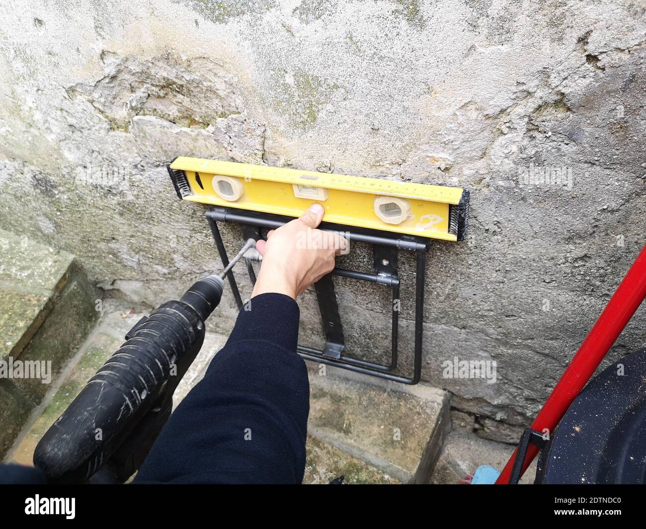 A carpenter using a level tool and a drill tool while working Stock ...