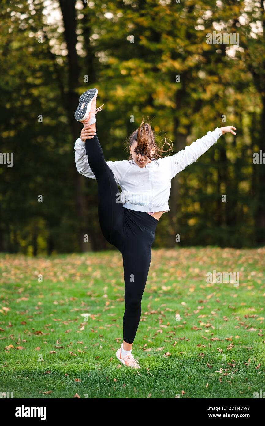 Woman in sport outfit in the park doing doing splits standing Stock ...