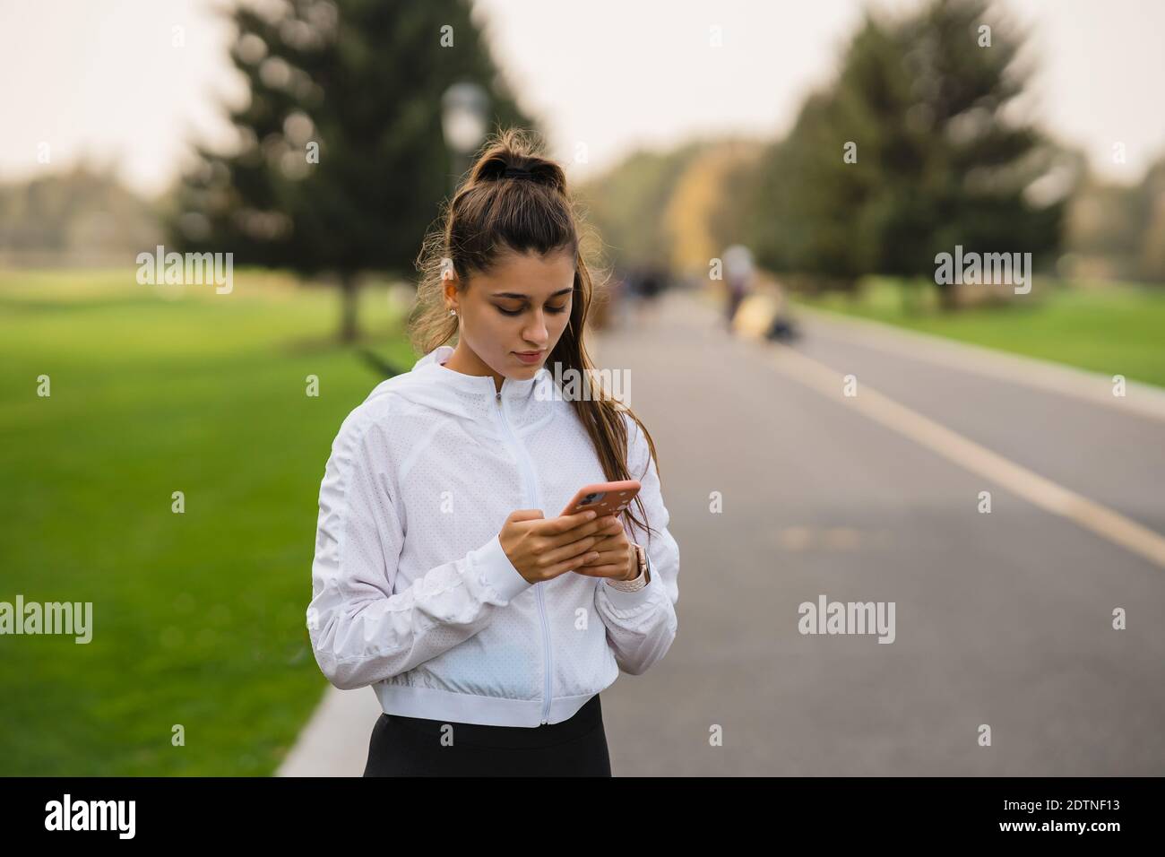 Girl athlete holds and uses smartphone after jogging Stock Photo - Alamy