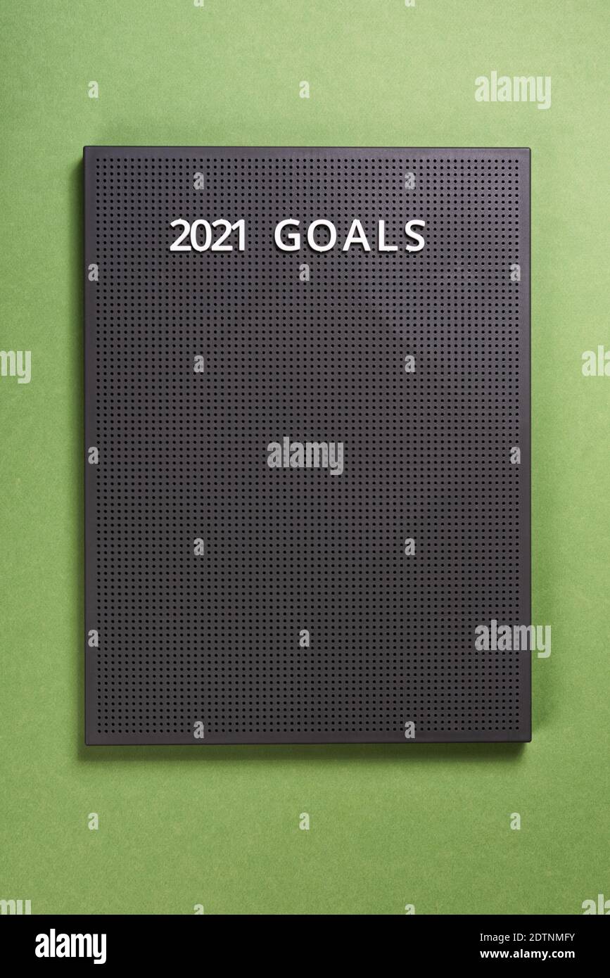 Goal, plan, action text on gray letter board. 2021 New year on green ...