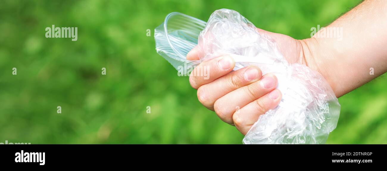 The person holds used crumpled plastic debris in his hand ...