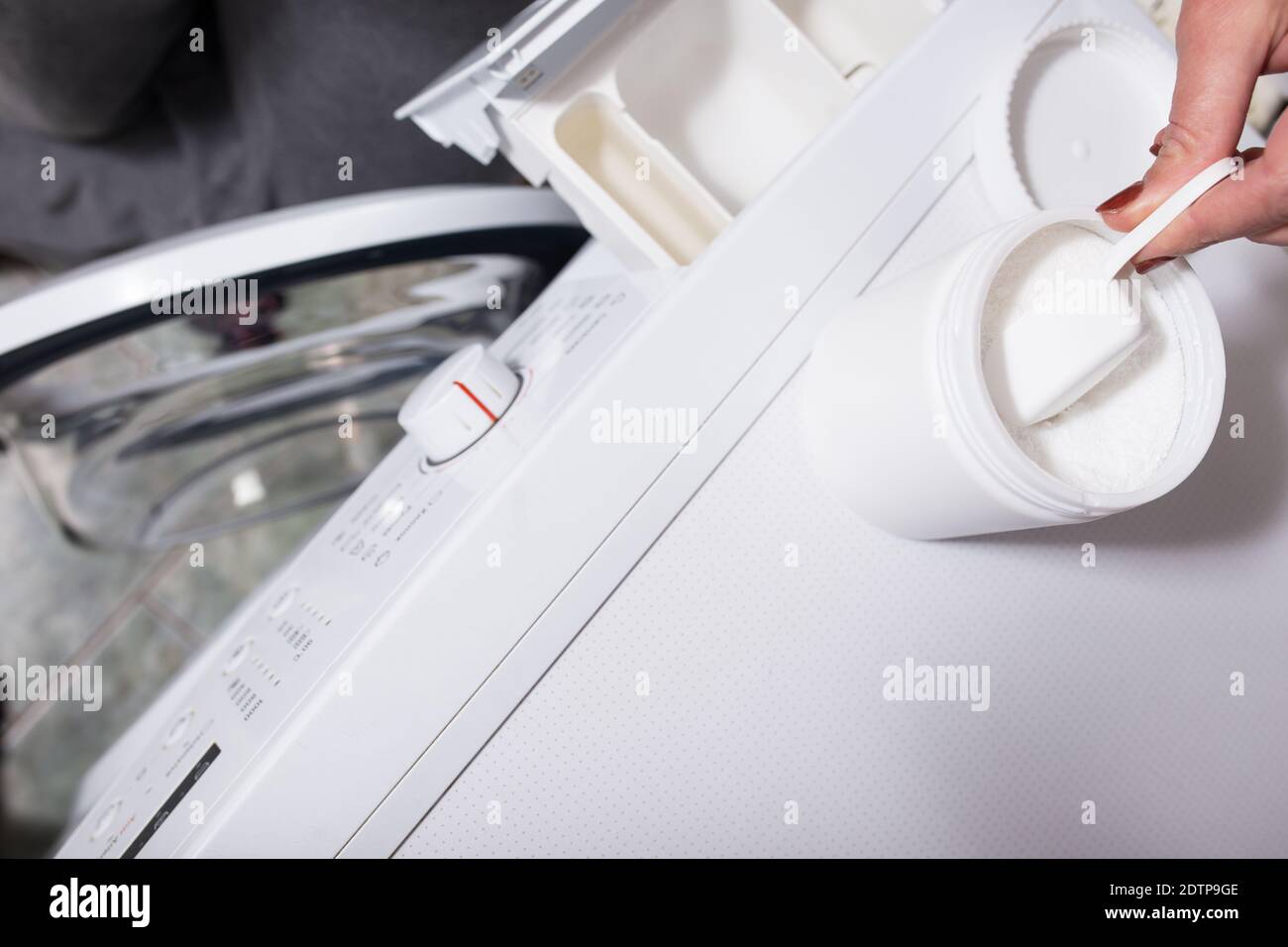 Woman's hands putting the powder in the washing machine Stock Photo - Alamy