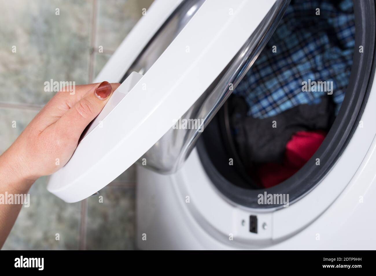 Woman's hand opening washing machine to load other clothes Stock Photo ...