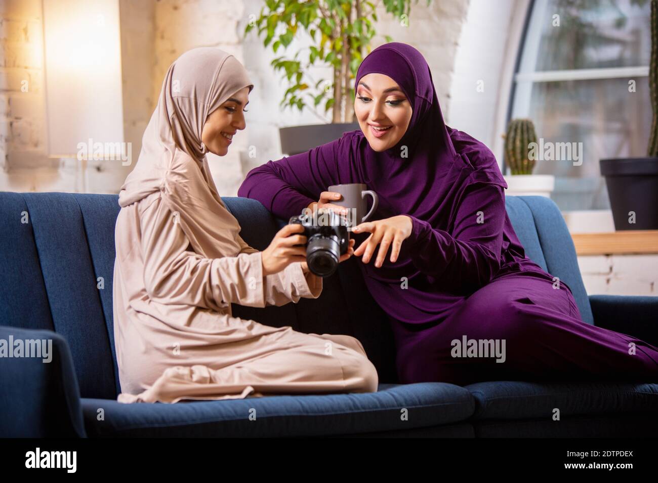 Friendship. Happy and young two muslim women at home talking, smiling ...