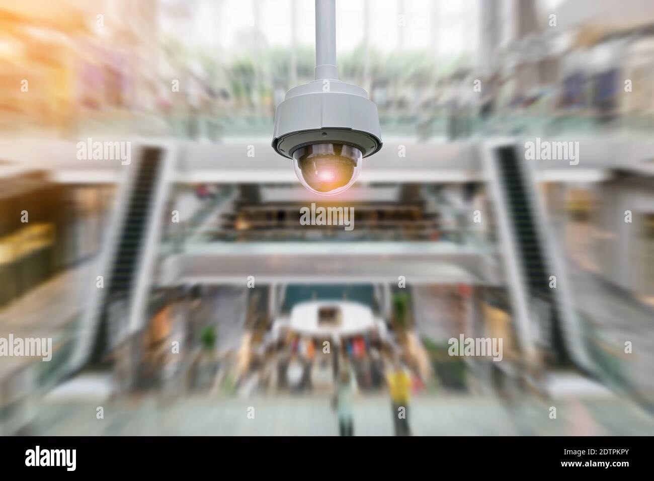 Closeup CCTV security camera on blurred inside shopping mall background ...