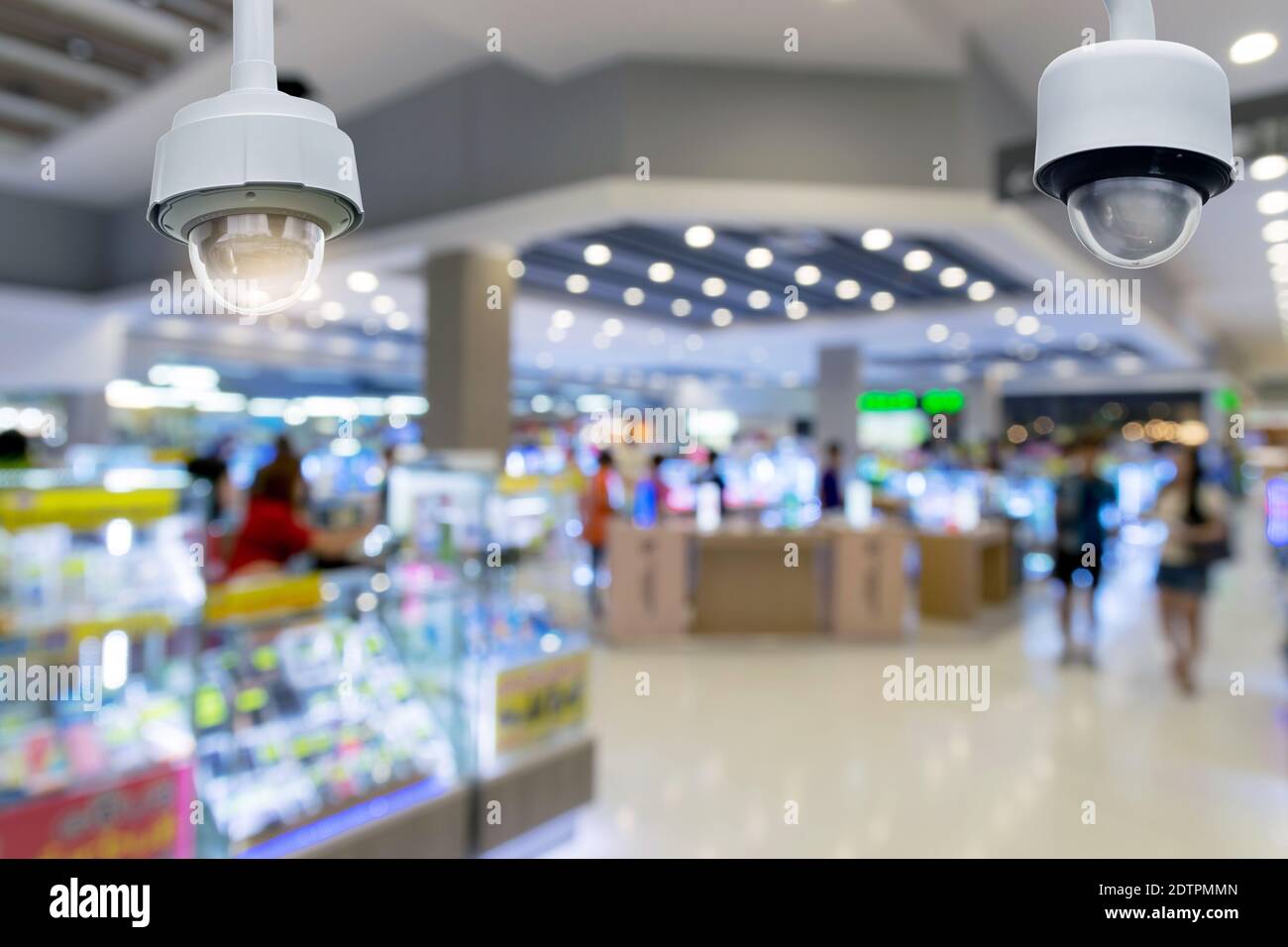 Closeup CCTV security camera on blurred inside shopping mall background ...