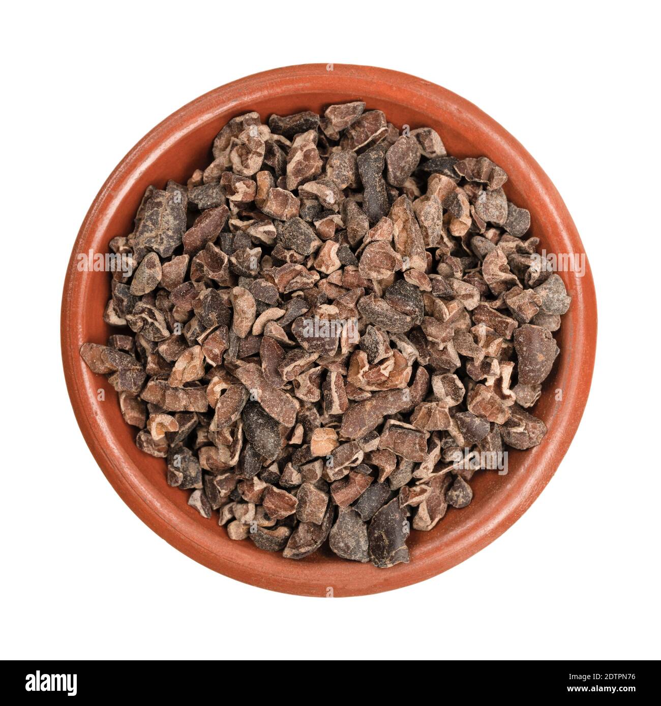 Top view of a small bowl of cocoa nibs isolated on a white background ...